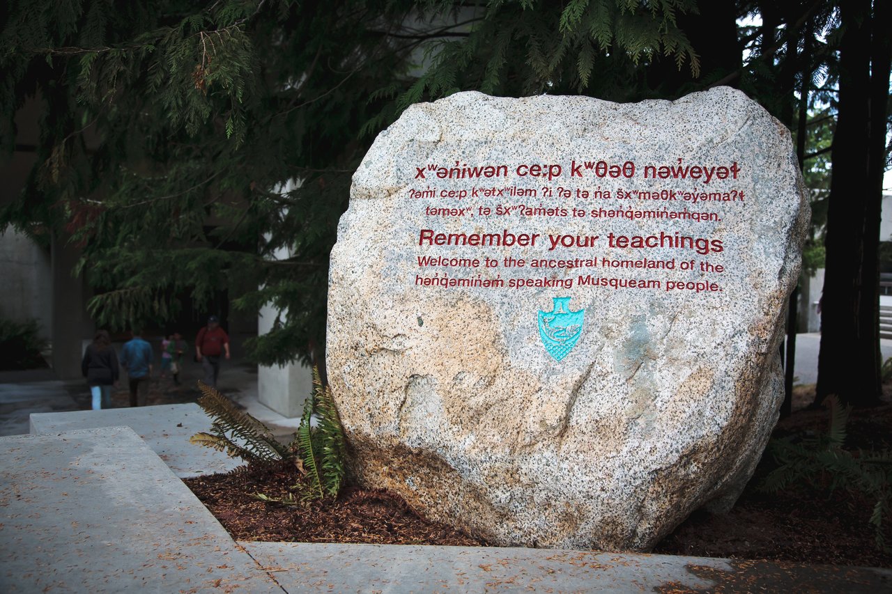 A stone with engraved text in English and the Musqueam language ...